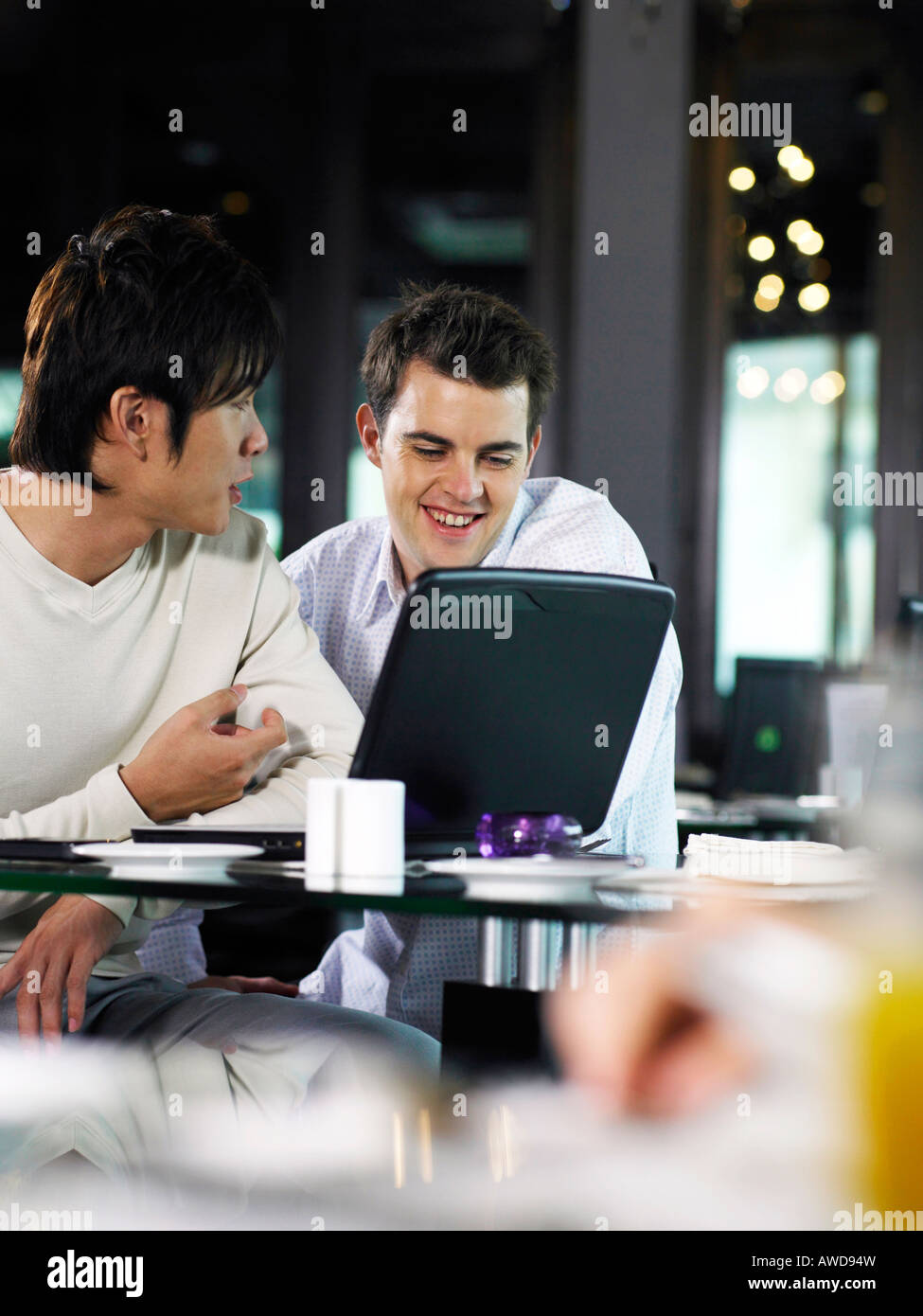 two men using laptop in the cafe, smiling Stock Photo - Alamy
