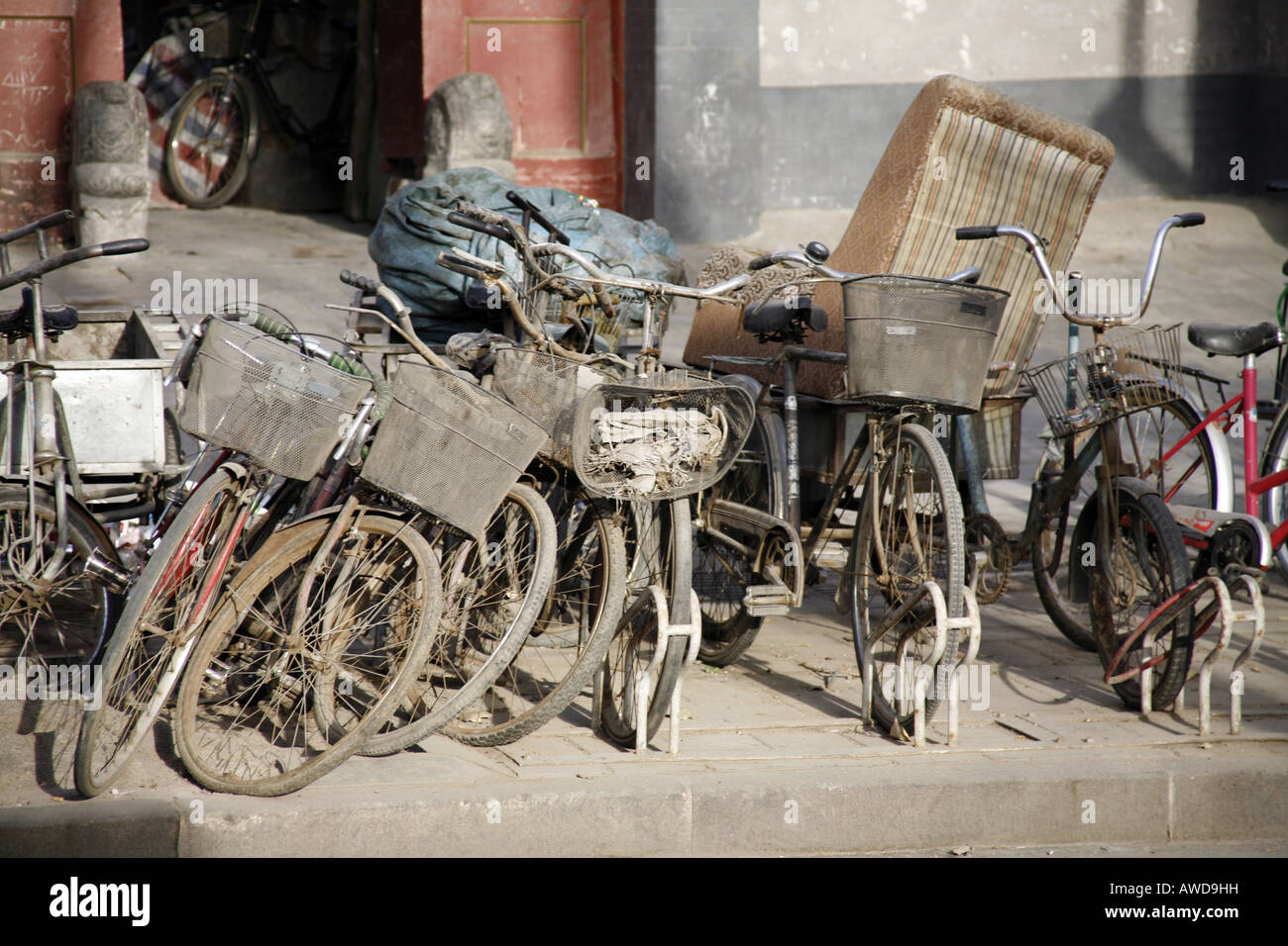 A dusty collection of bicycles clutter the pavement outside the faded ...