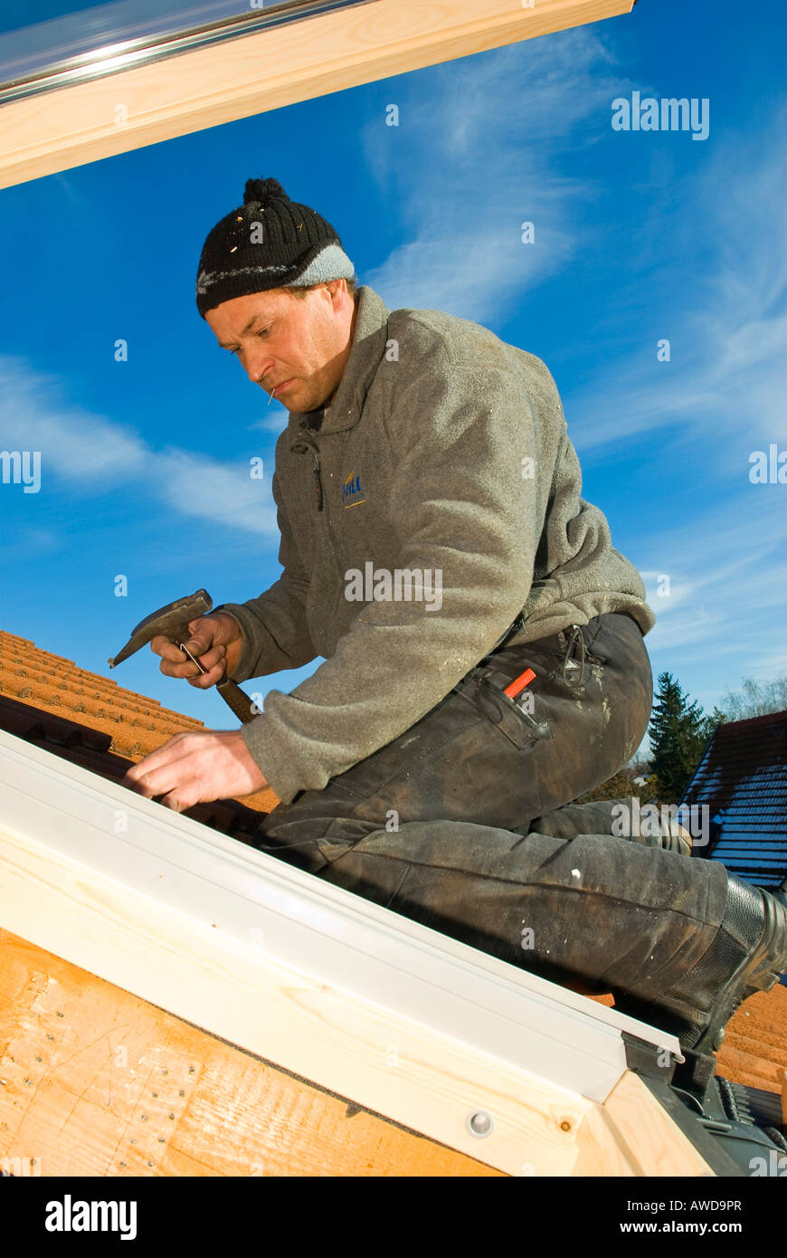 Carpenter mounting a roof window Stock Photo - Alamy