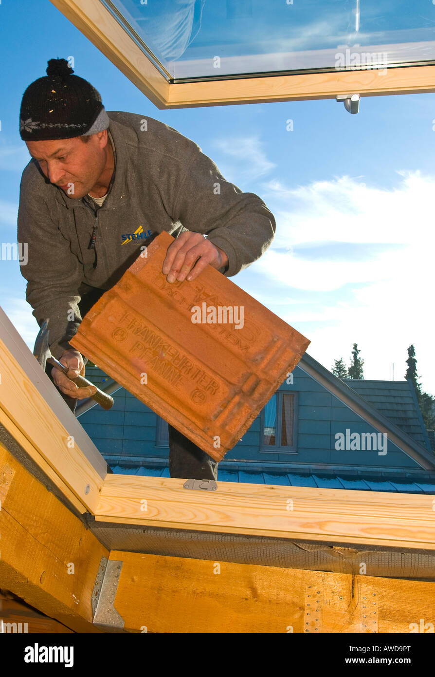 Carpenter mounting a roof window Stock Photo - Alamy