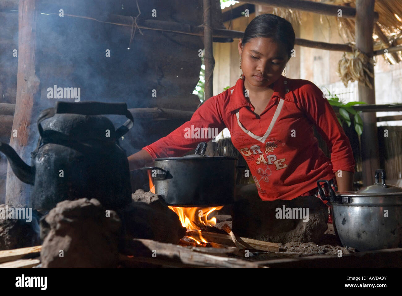 Girl cooking on open fire in a traditional kitchen, Koh Kong Province ...
