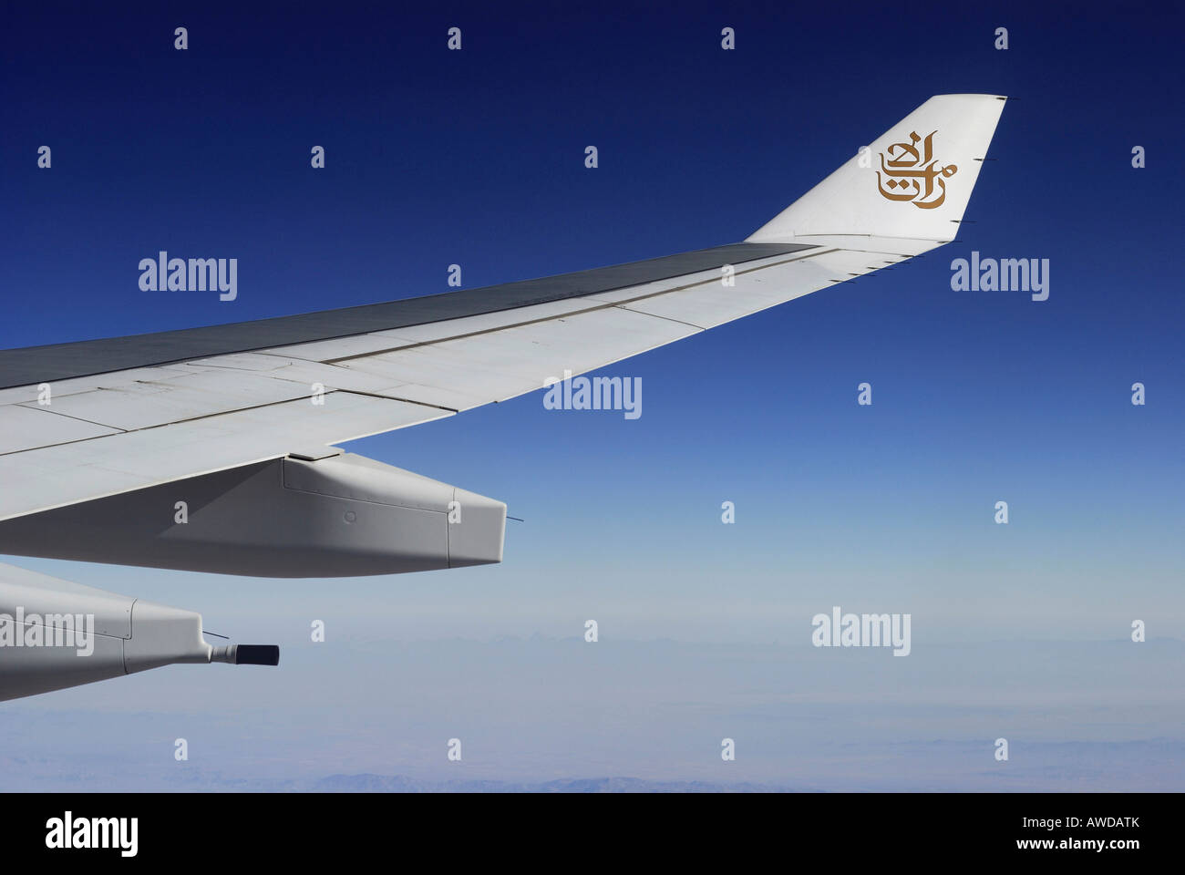 Wing of a flying Airbus 330-200 of the airline "Emirates" and blue sky ...