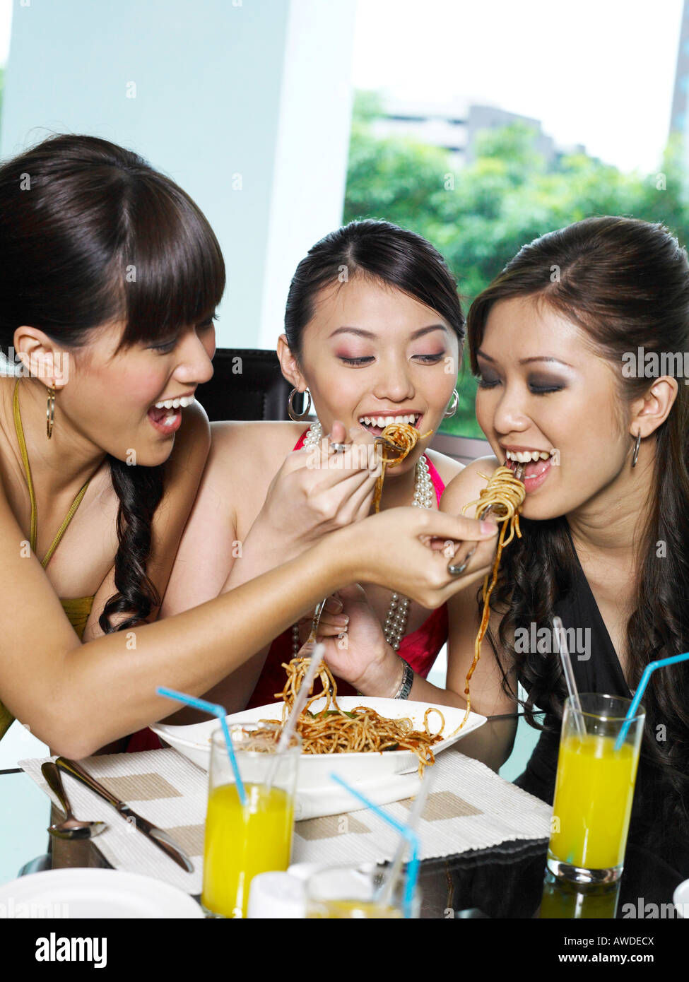 three women sharing food, eating out at restaurant Stock Photo - Alamy