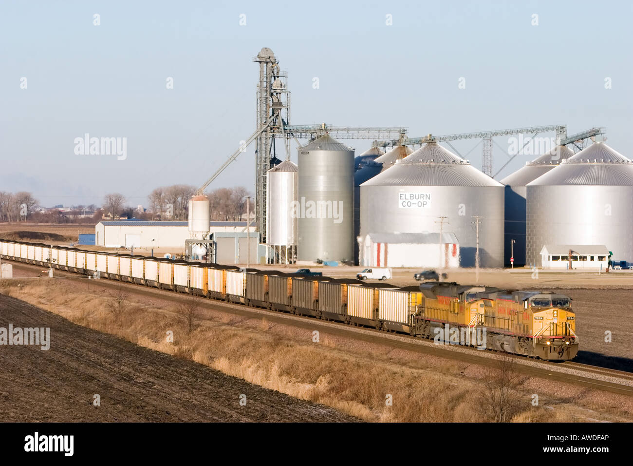 A loaded coal train passes a rural grain elevator Stock Photo - Alamy