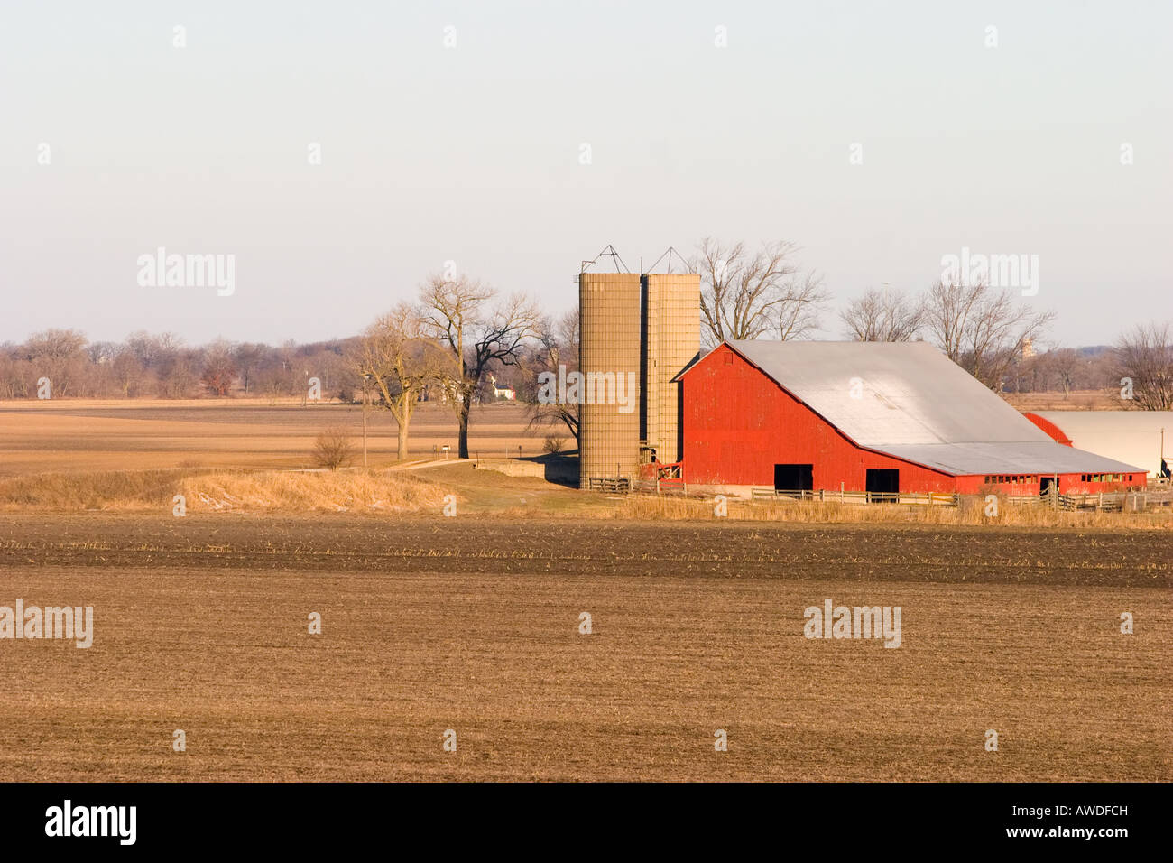 A red barn sits amongst barren and empty fields on a cold winter day ...