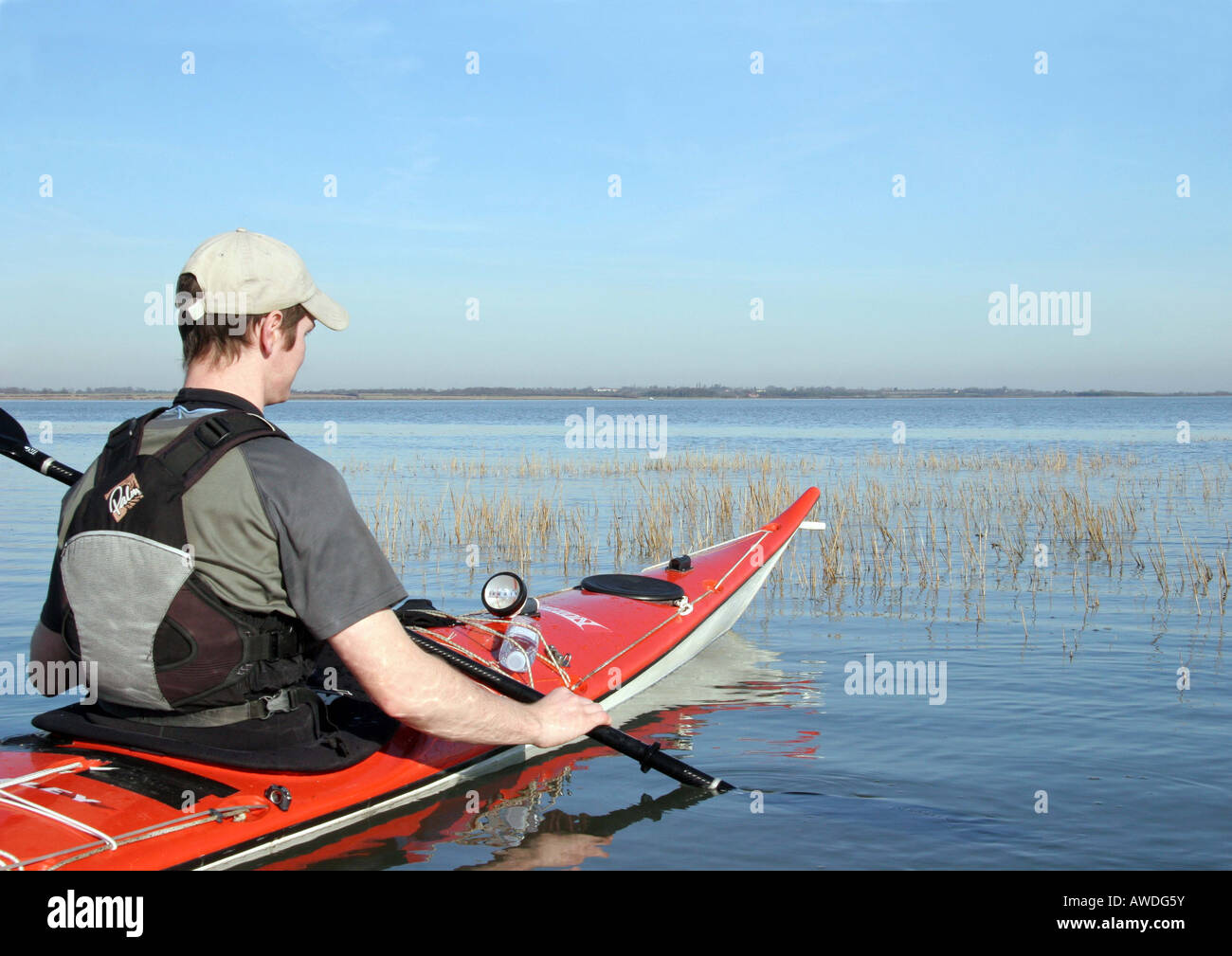 young man sea kayaking in a red kayak looking out to the horizon Stock ...