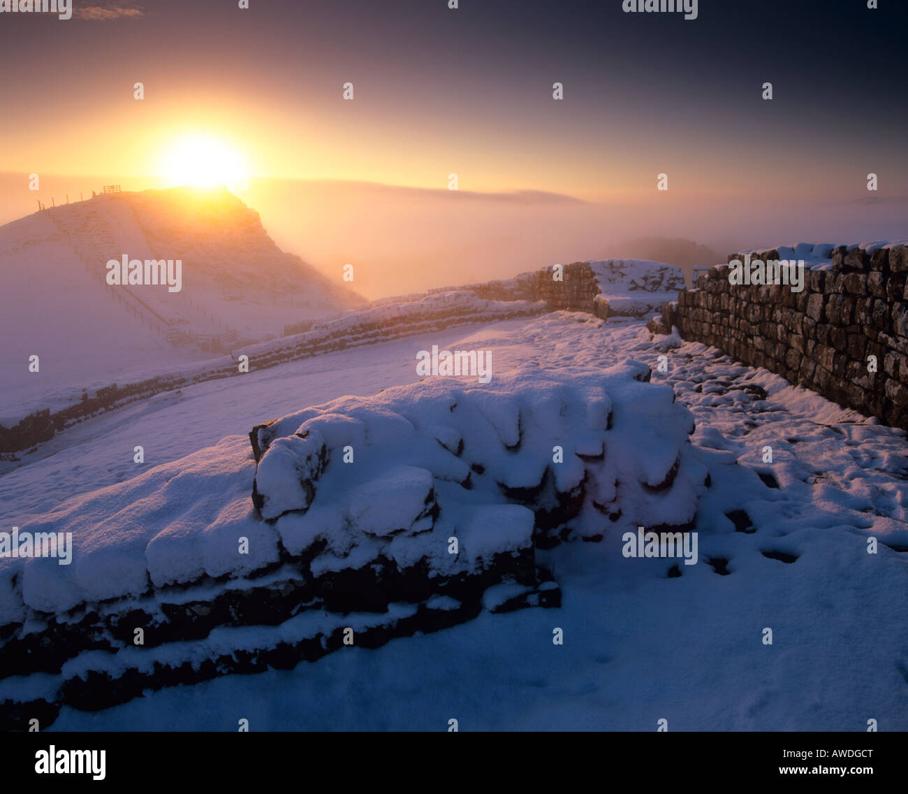 the winter sun sets through mist and snow at Milecastle 42 on Hadrian's ...