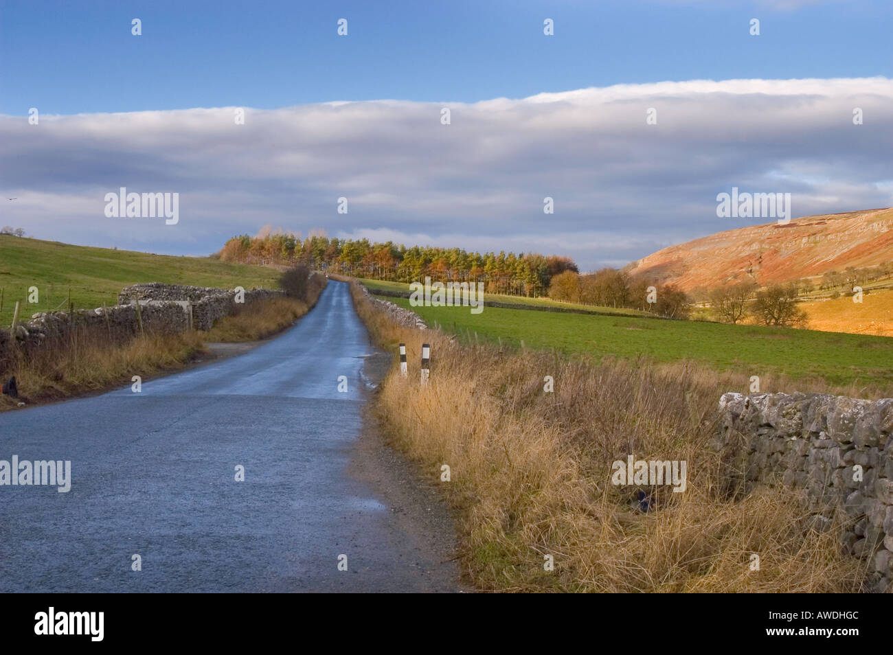 Small country road in the hills with drystone walls either side a small ...