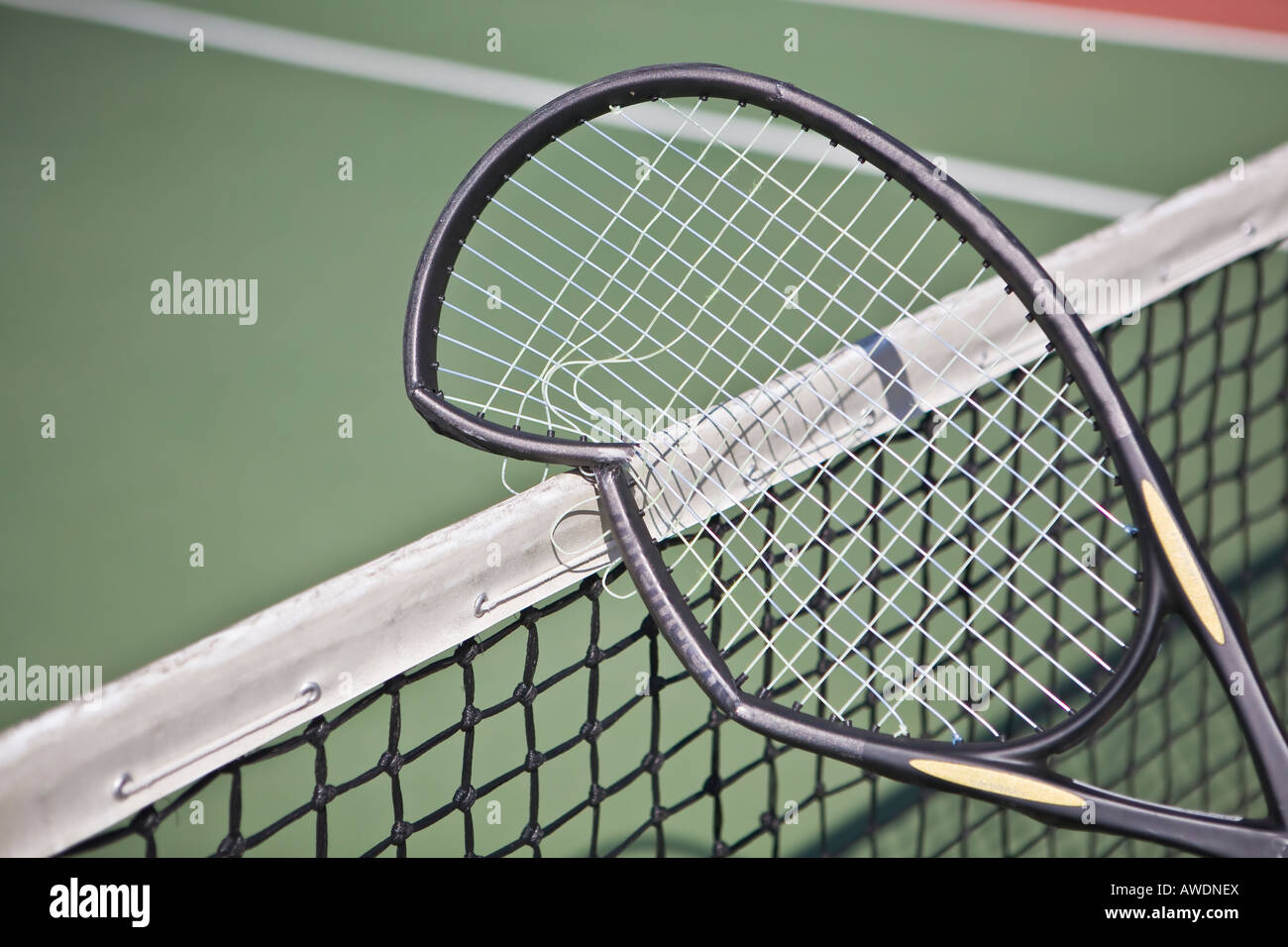 broken tennis racket resting on net cord Stock Photo - Alamy