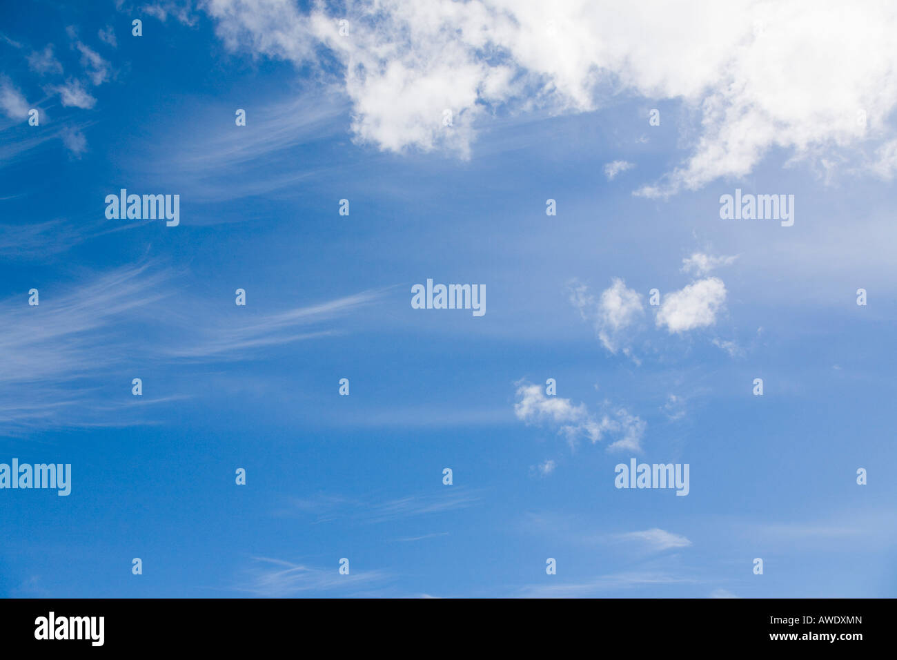 Blue sky with fluffy white cumulus clouds and cirrus mare's tail cloud ...