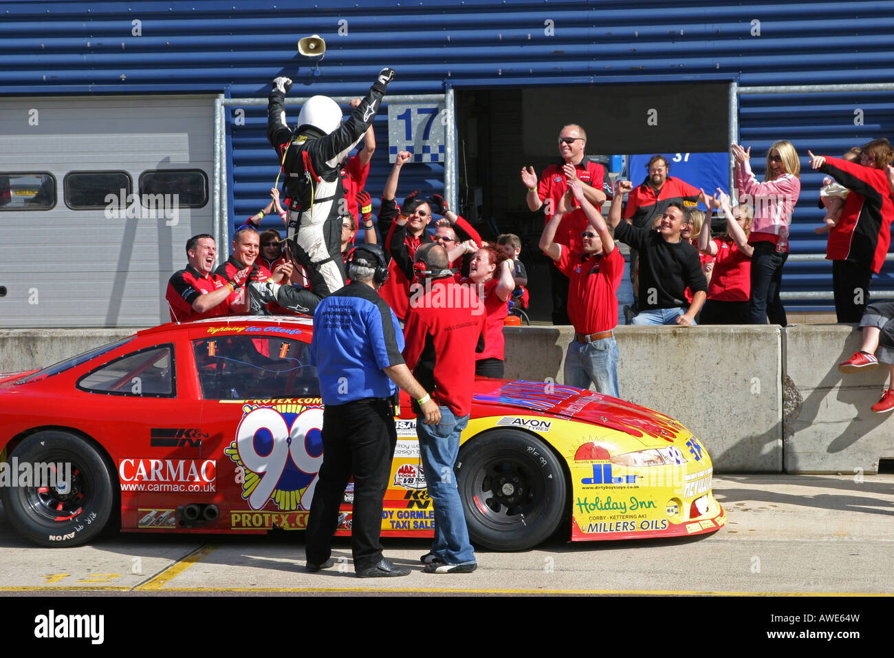 V8 stock car in pit lane with driver celebrating with pit crew after ...