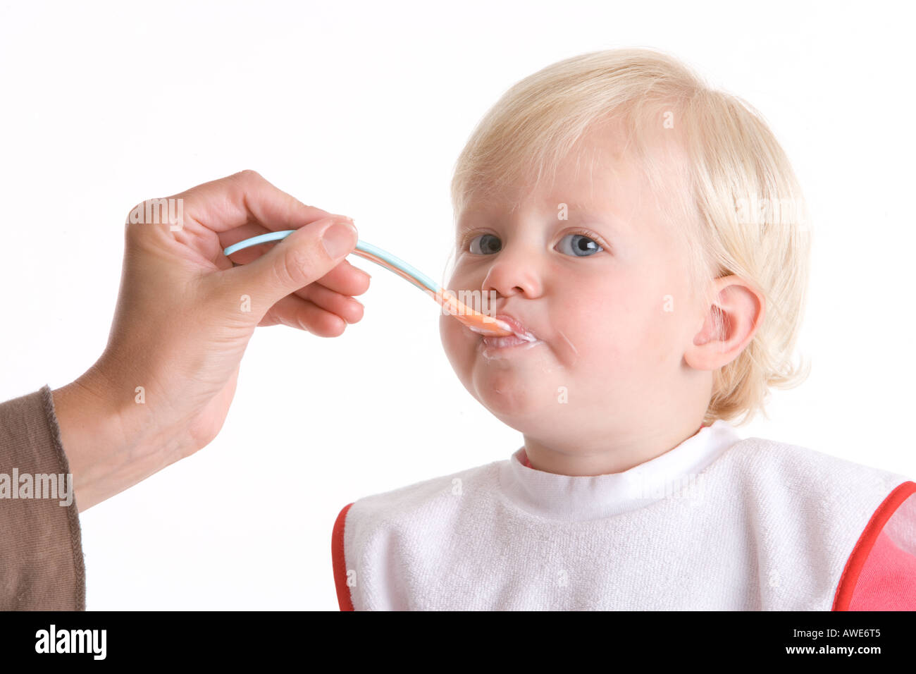 Little girl is fed with a spoon Stock Photo - Alamy