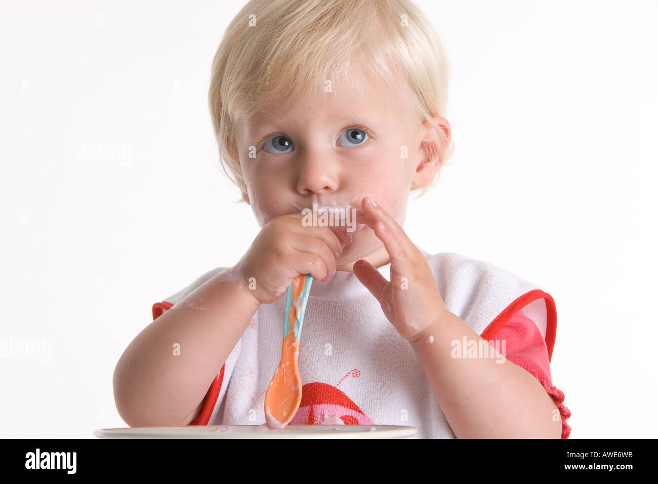 Little girl eating by herself Stock Photo - Alamy