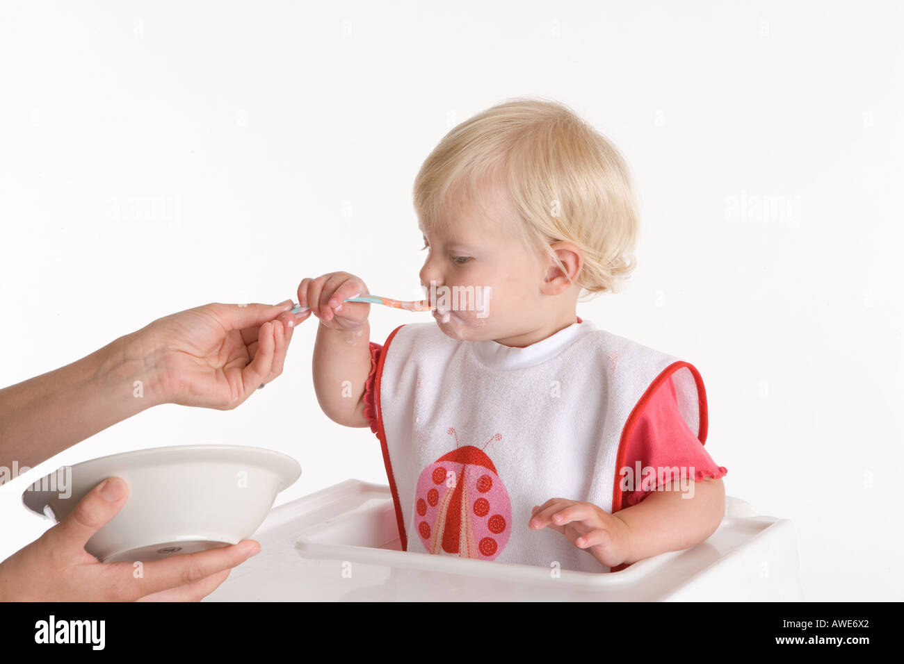 Little girl eating by herself Stock Photo - Alamy