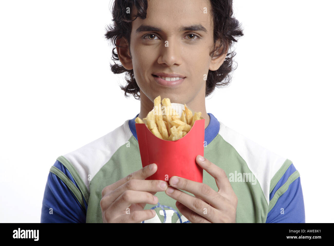 ANG200421 Teenage boy standing holding packet of potato finger chips ...