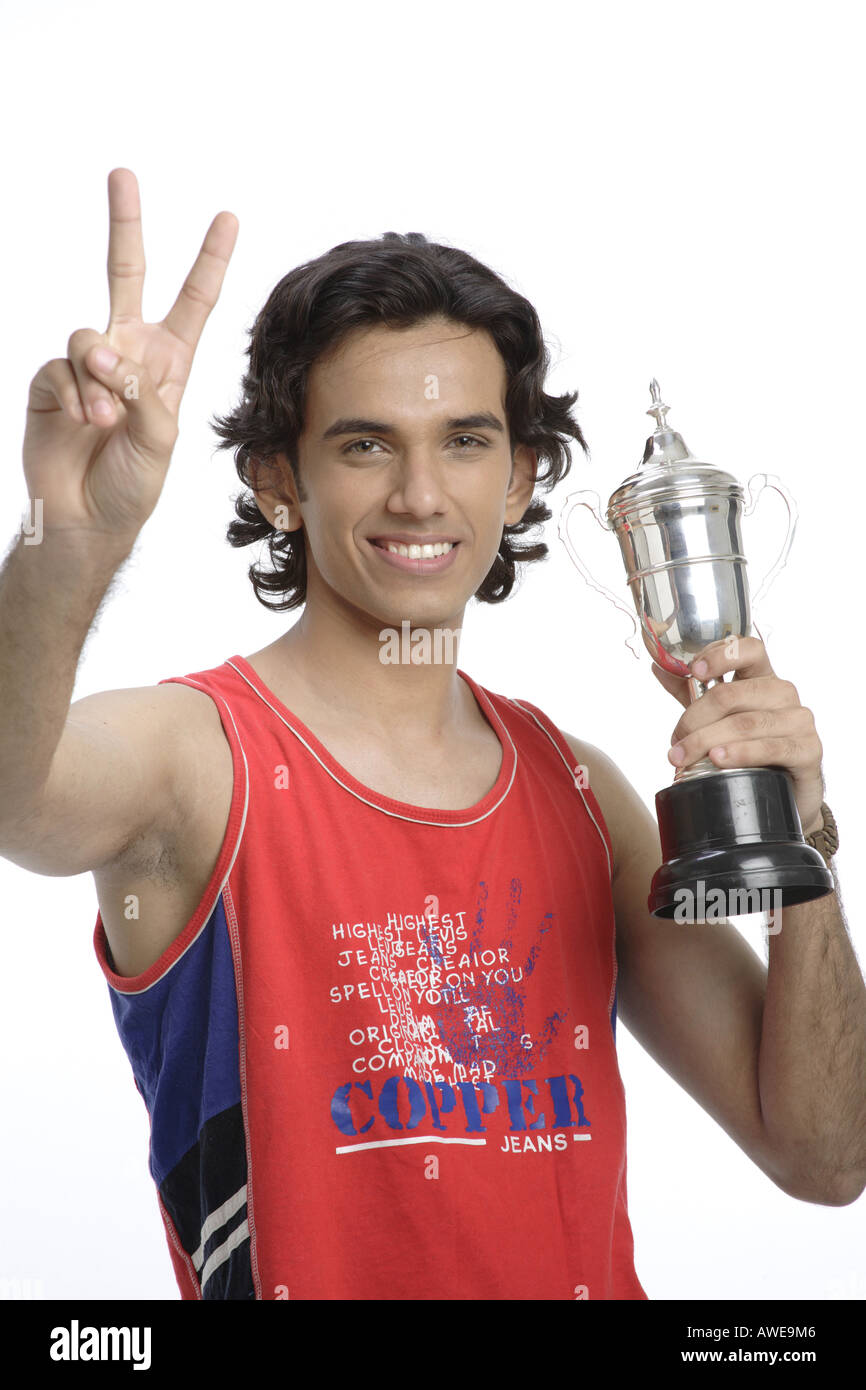 ANG200550 Teenage boy winning trophy cup success showing victory sign ... ANG200550 Teenage boy winning trophy cup success showing victory sign ...
