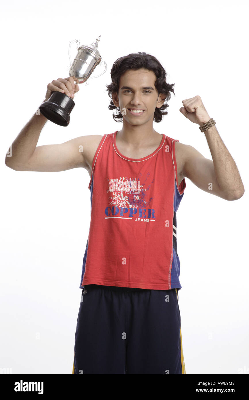 ANG200551 Teenage boy winning trophy cup success raising the trophy MR ... ANG200551 Teenage boy winning trophy cup success raising the trophy MR ...