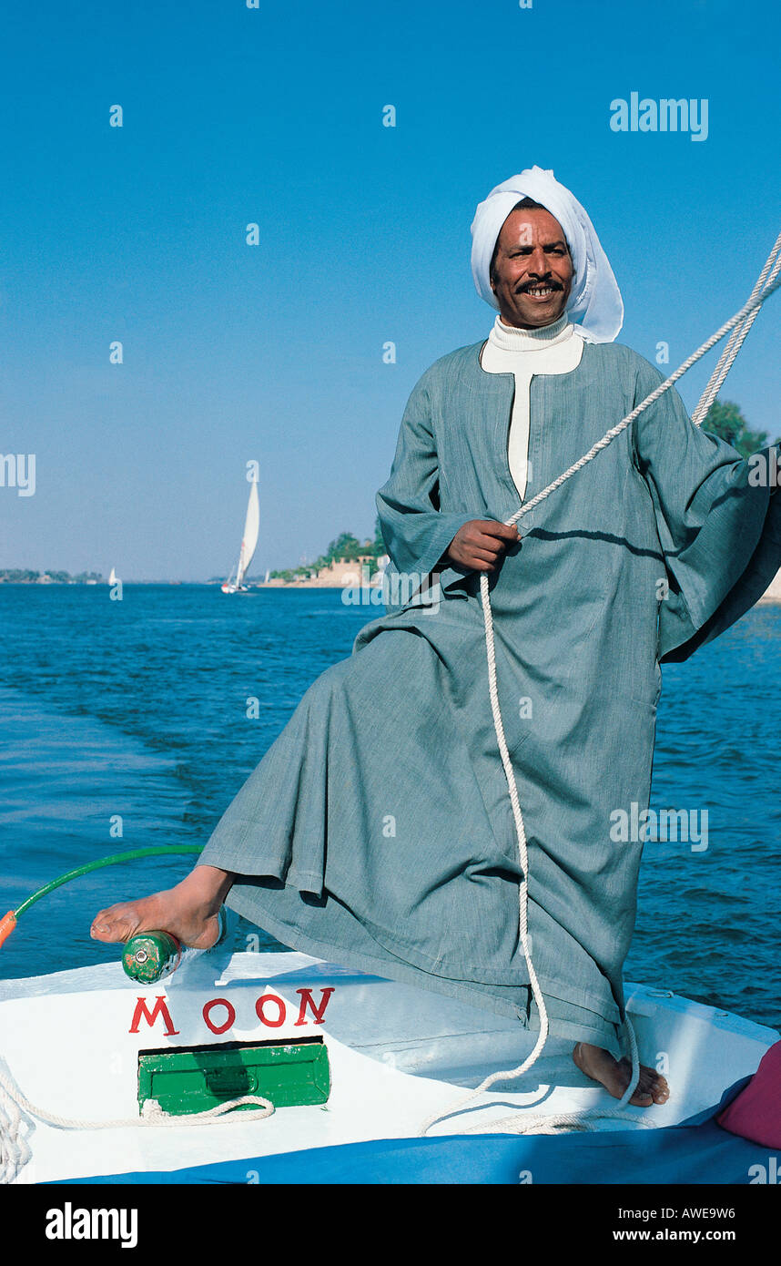 Egyptian sailor at the helm of his FELUCCA on the River Nile at Luxor ...
