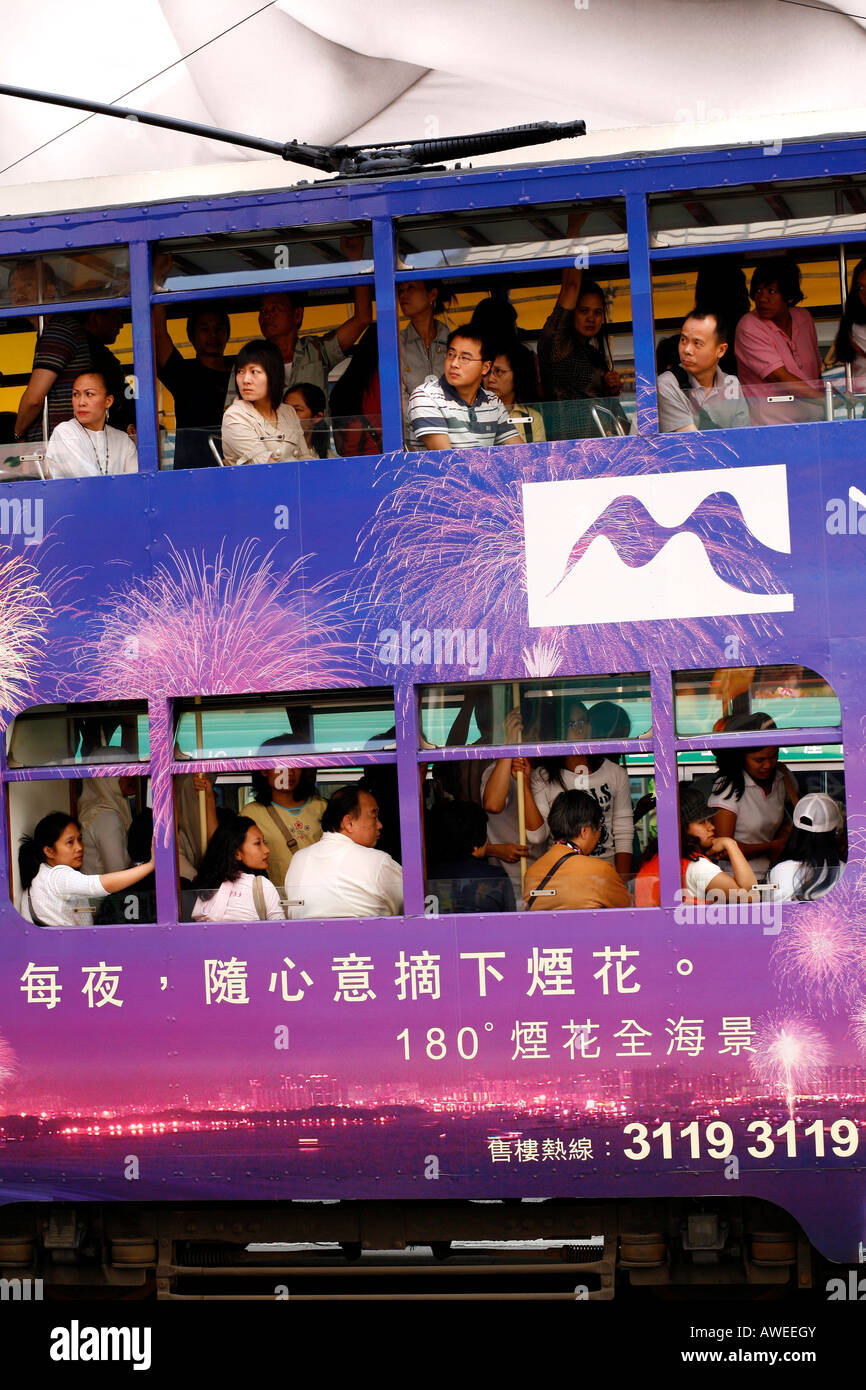 Passengers aboard a double-decker tram bus with advertising in Hong ...