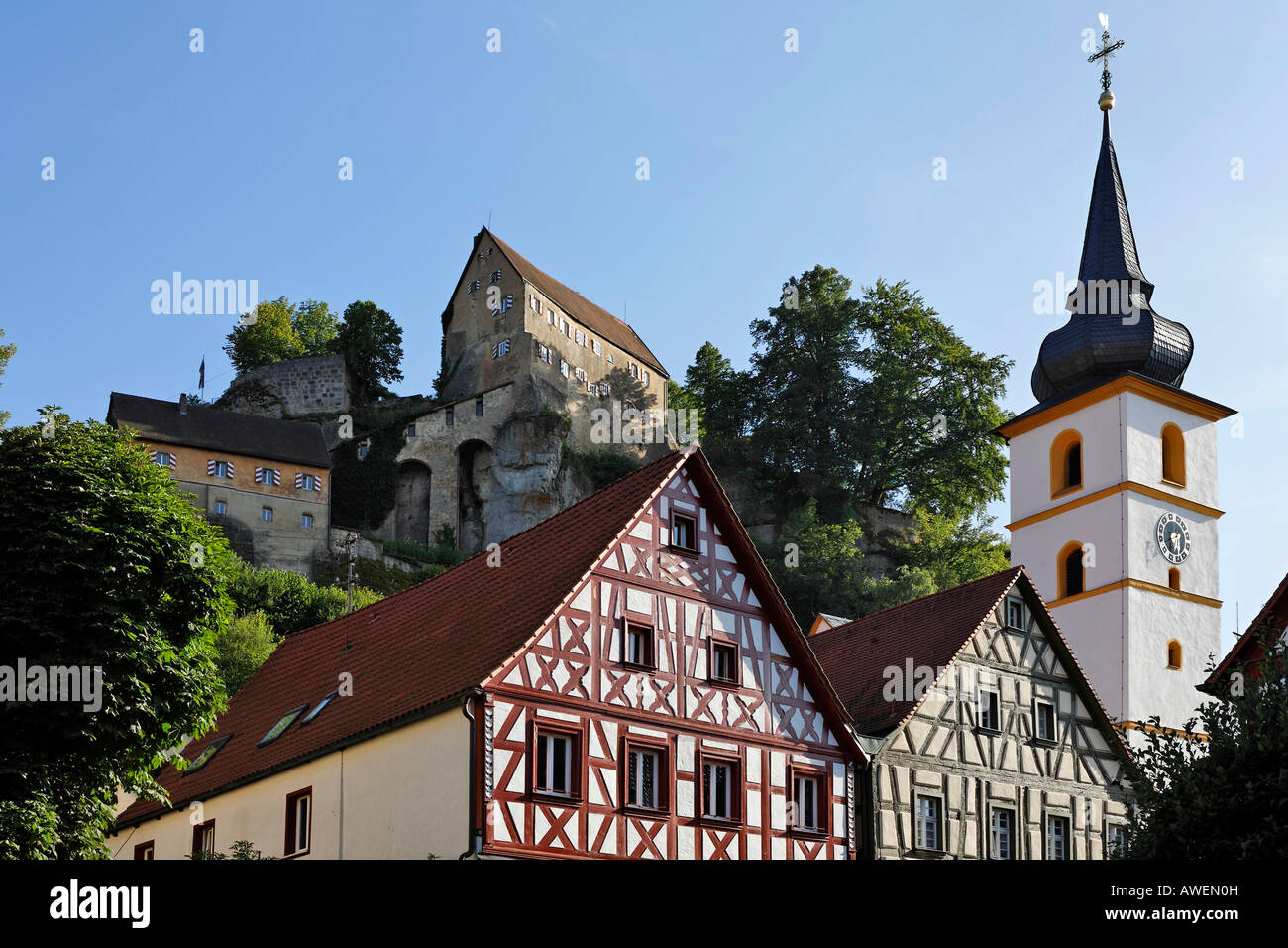 Fachwerk-style houses and church in front of the castle at Pottenstein ...