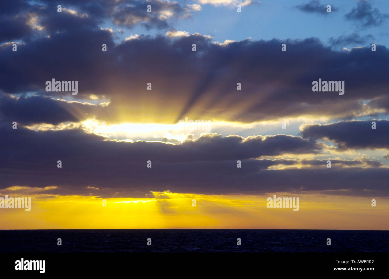 Sunset with sunburst and clouds over the Atlantic Ocean from a cruise ...