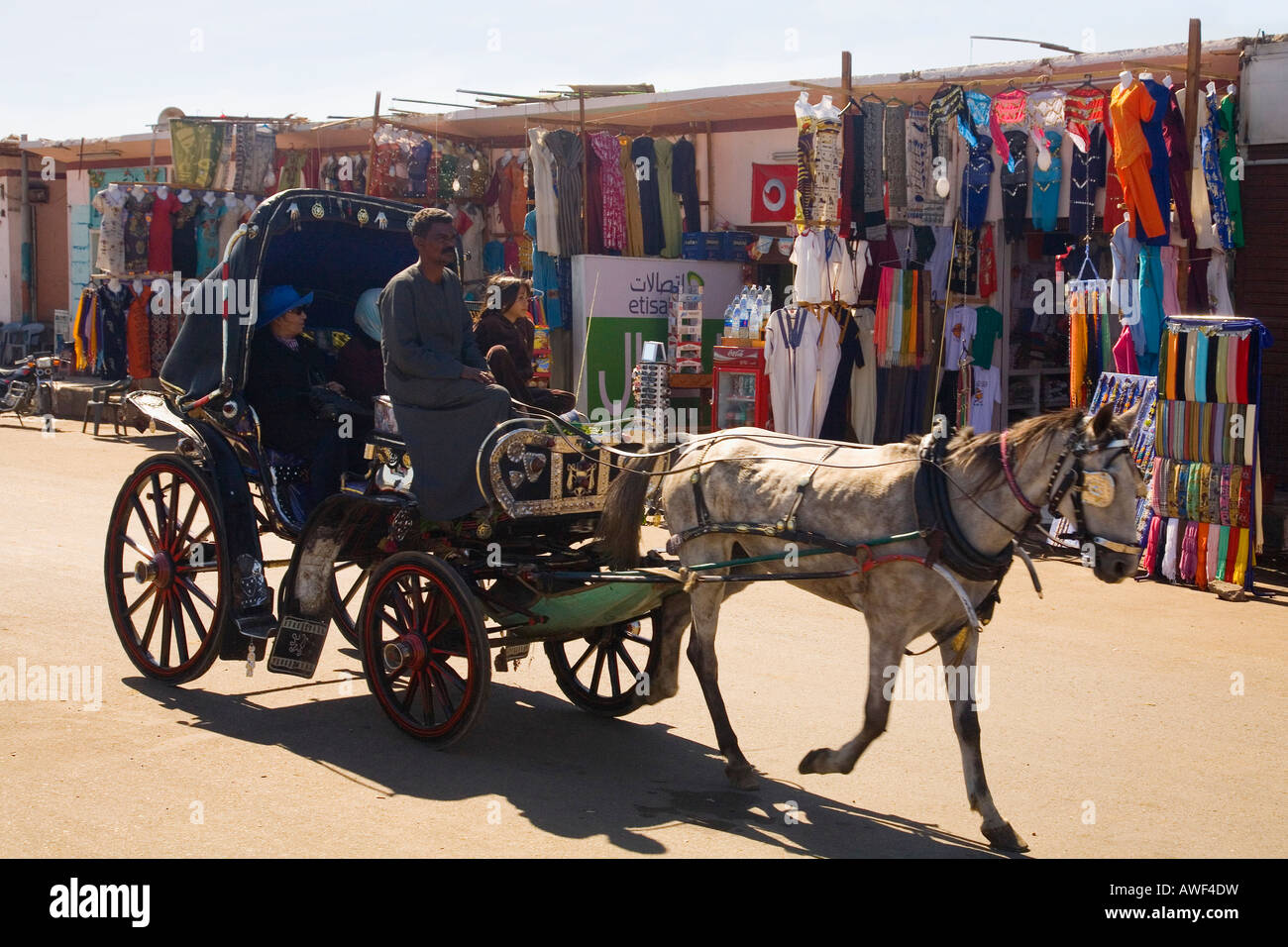 Horse drawn carriage or Hantour carries tourists past market stalls and ...