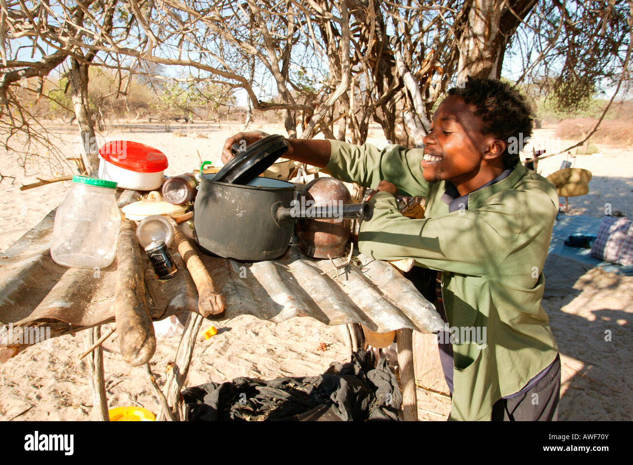 Man storing food and dishes on corrugated metal roof and tree to ...