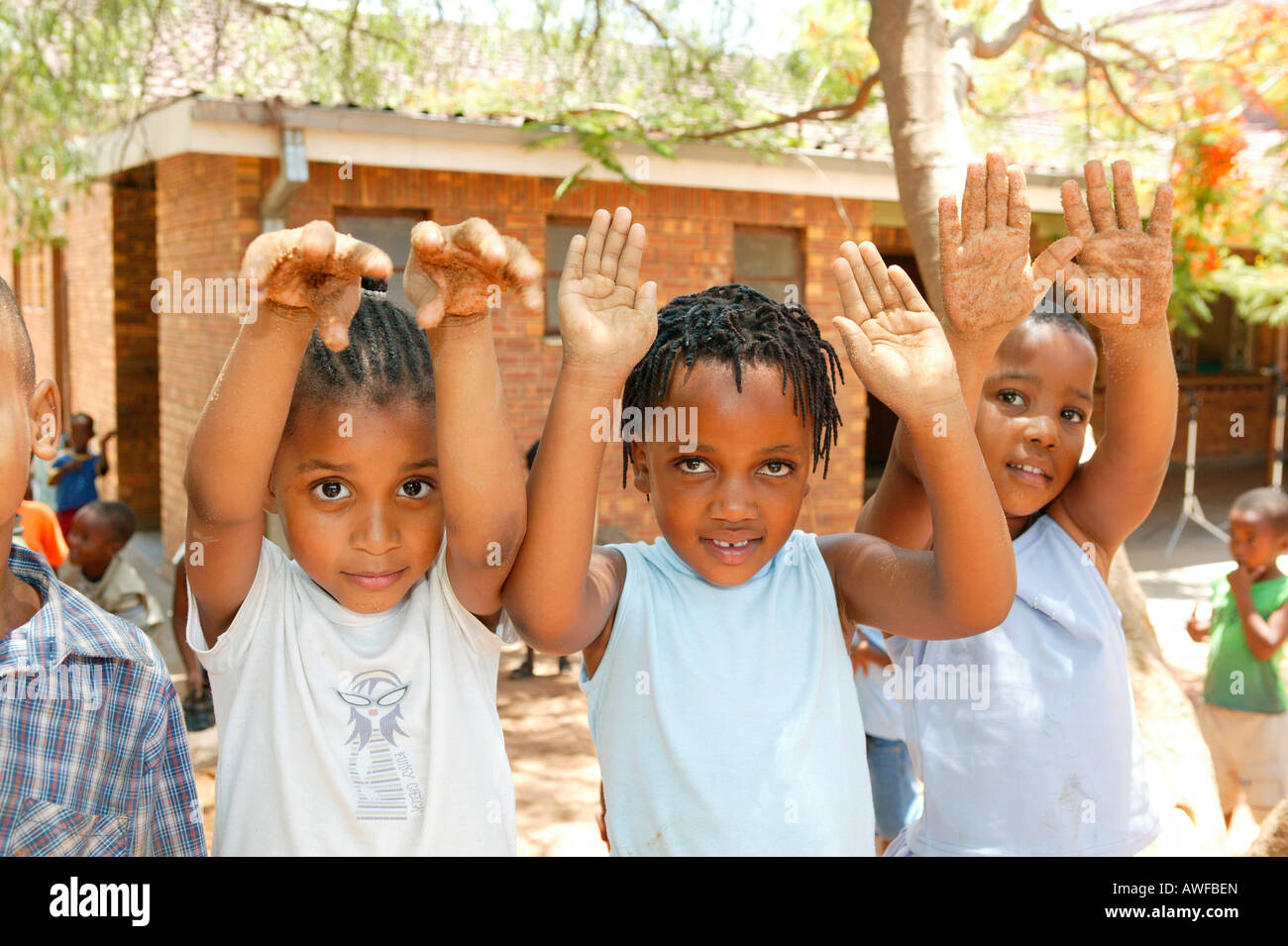 Three girls showing their sandy hands at a kindergarten, Gaborone ...