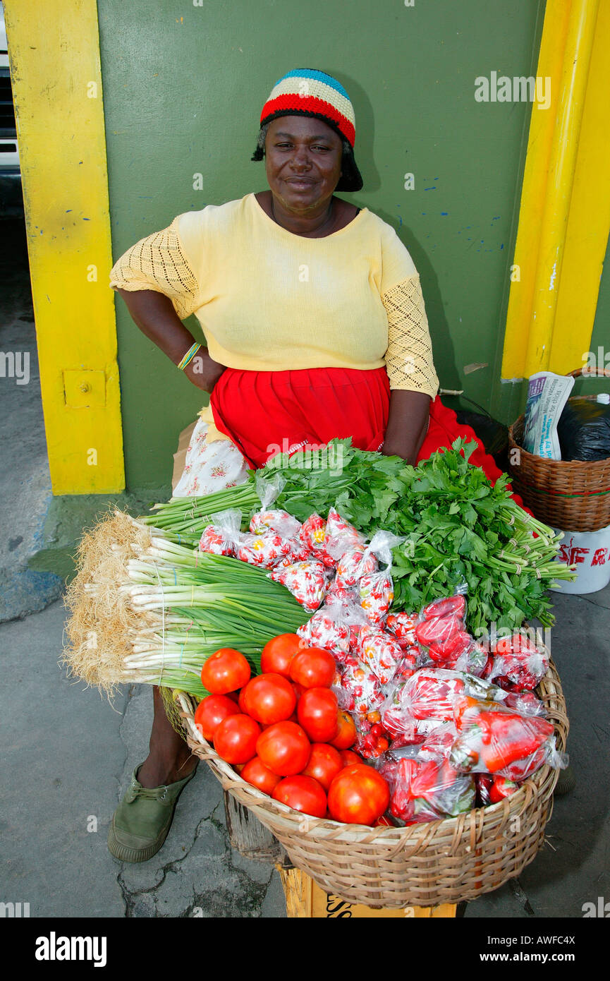 Caribbean woman standing behind a basket filled with produce on the ...