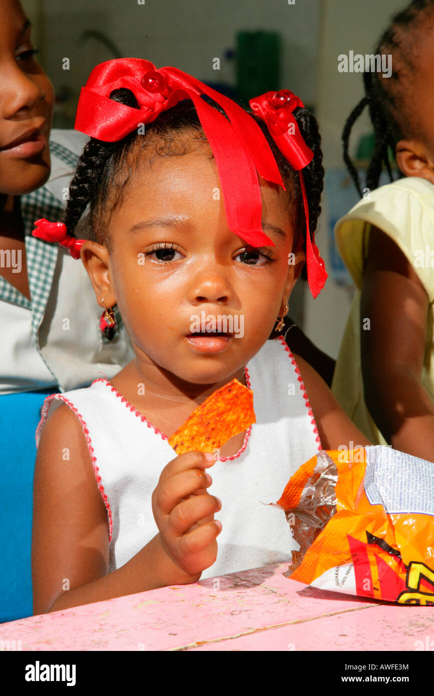 Girl eating nachos at a kindergarten in New Amsterdam, Guyana, South ...