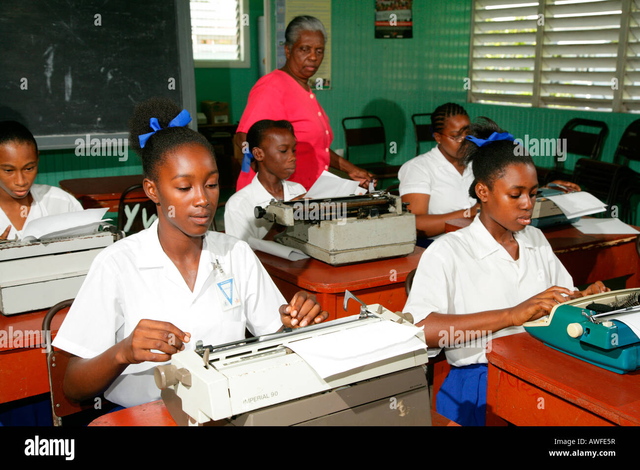 Girls wearing school uniforms in typing class at a training centre for ...