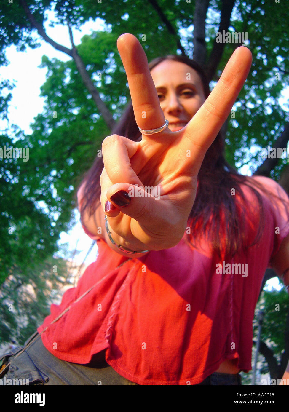 Woman in Park Making Peace Sign Gesture Stock Photo - Alamy
