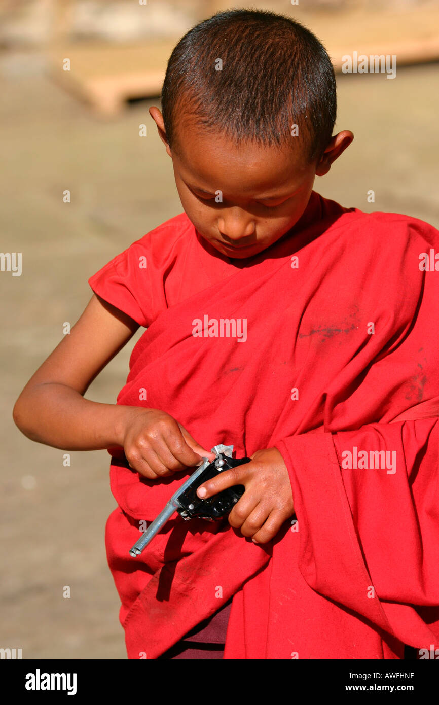 Child-monk playing with his toy gun Stock Photo - Alamy