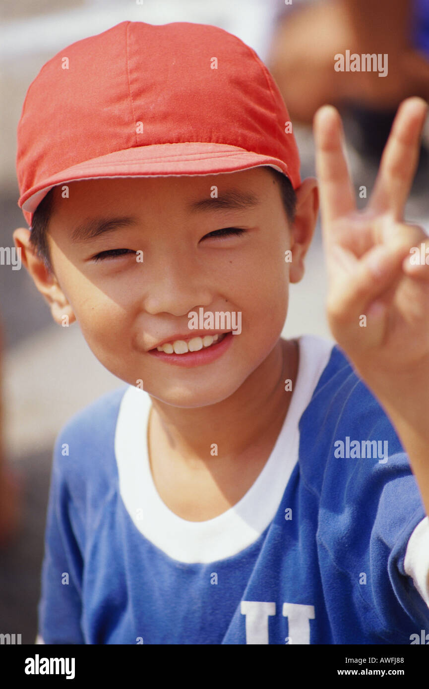 Boy giving peace sign Stock Photo - Alamy