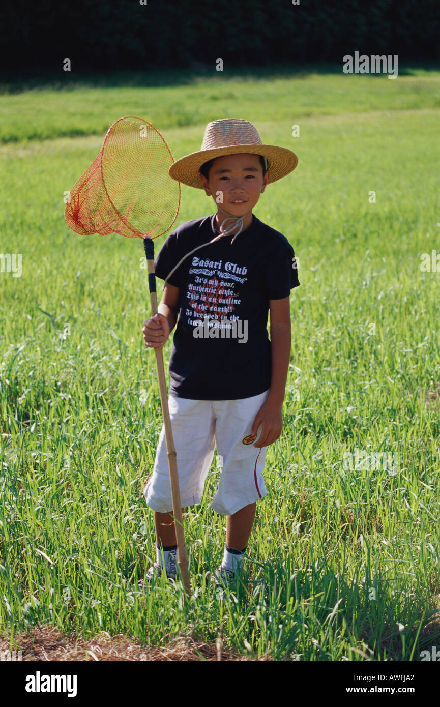 Boy standing in field with butterfly net Stock Photo - Alamy