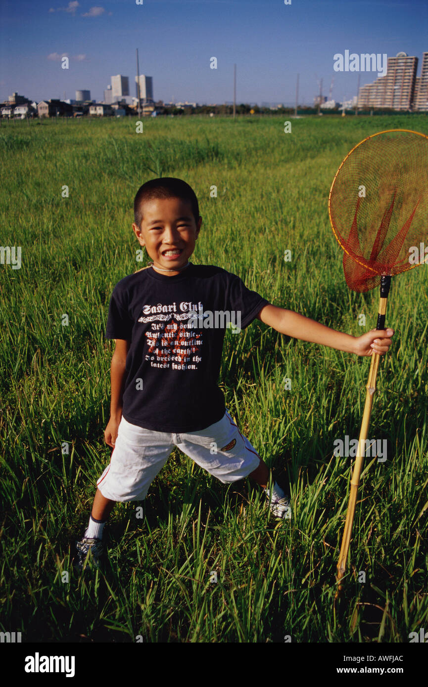 Boy standing in field with butterfly net Stock Photo - Alamy