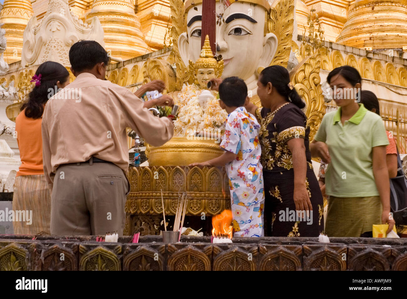 Stock photograph of worshipers bathing idols at the golden Shwedagon ...