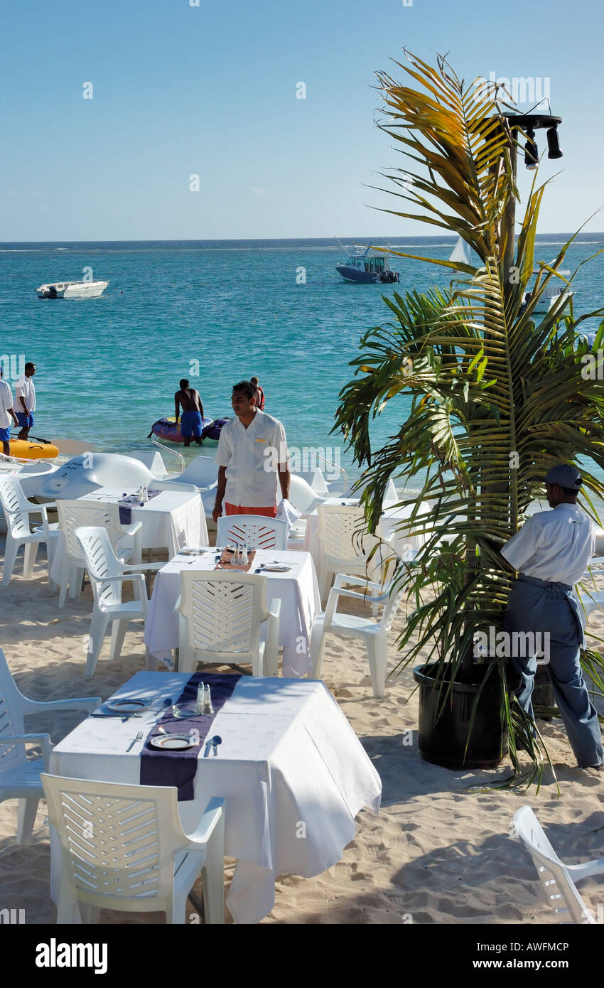 Hotel employees preparing dinner tables on a beach Mauritius island ...