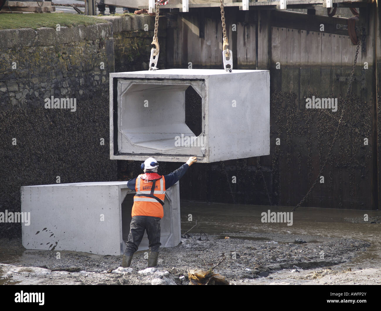 Workman directing 5 tonne concrete blocks into Bude canal to stem the ...