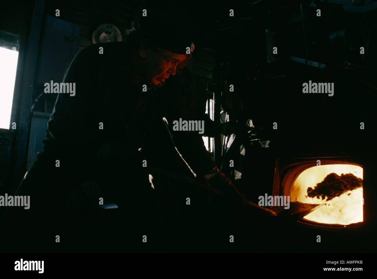 Russian train driver shovelling coal into the firebox of a Type SU ...