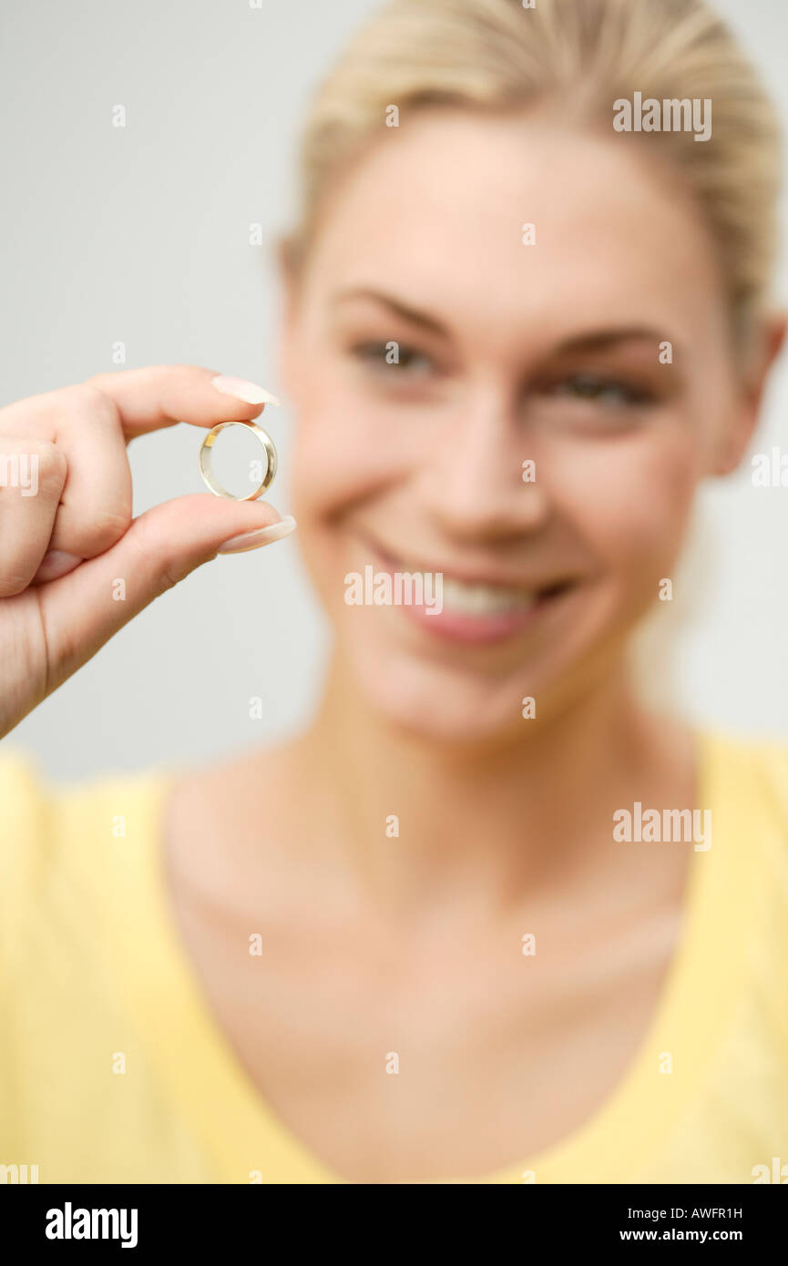 Young blonde woman looks at a wedding ring and smiles Stock Photo - Alamy