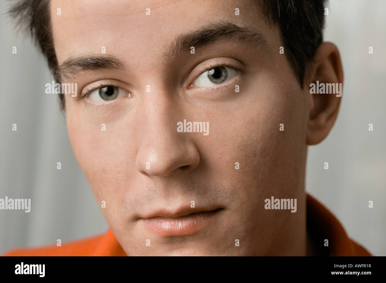 Young man sceptically looking into the camera, close-up Stock Photo - Alamy