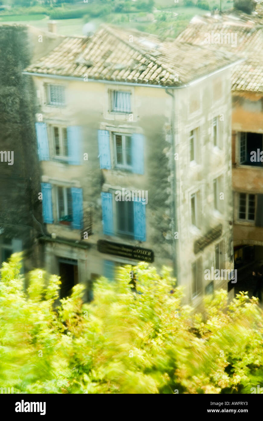 typical provencal building seen through a patterned window in Gordes ...