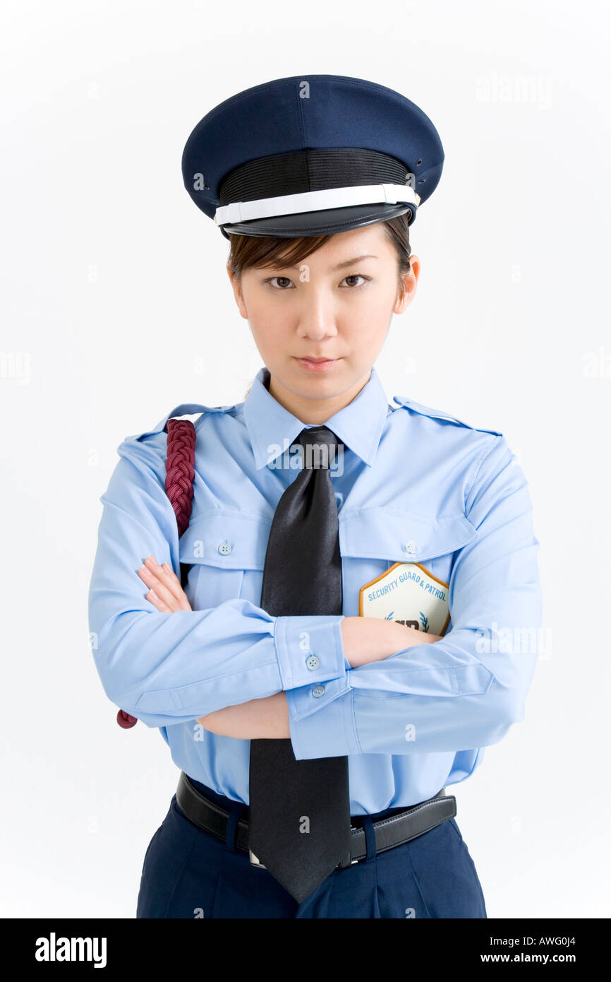 A female security guard standing with her arms crossed Stock Photo - Alamy