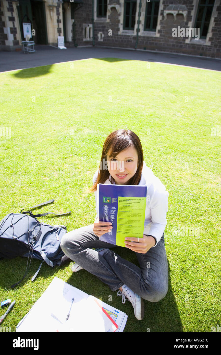 Young woman sitting on lawn Stock Photo - Alamy