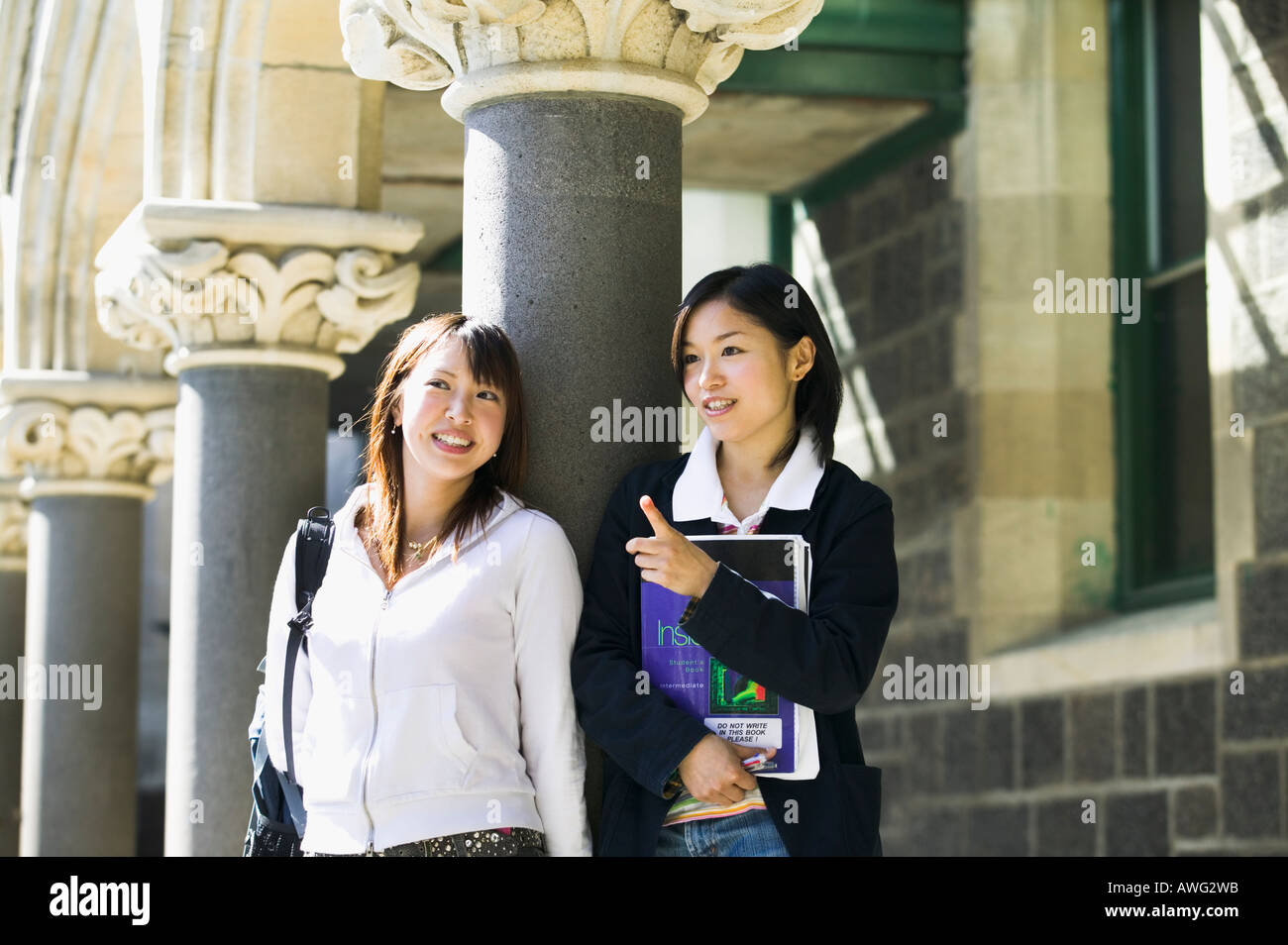 Two young women talking on campus Stock Photo - Alamy