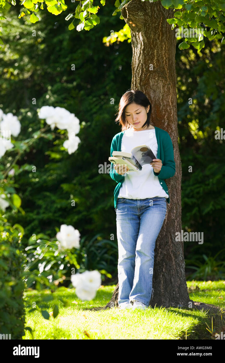 Woman under tree relaxing book hi-res stock photography and images - Alamy