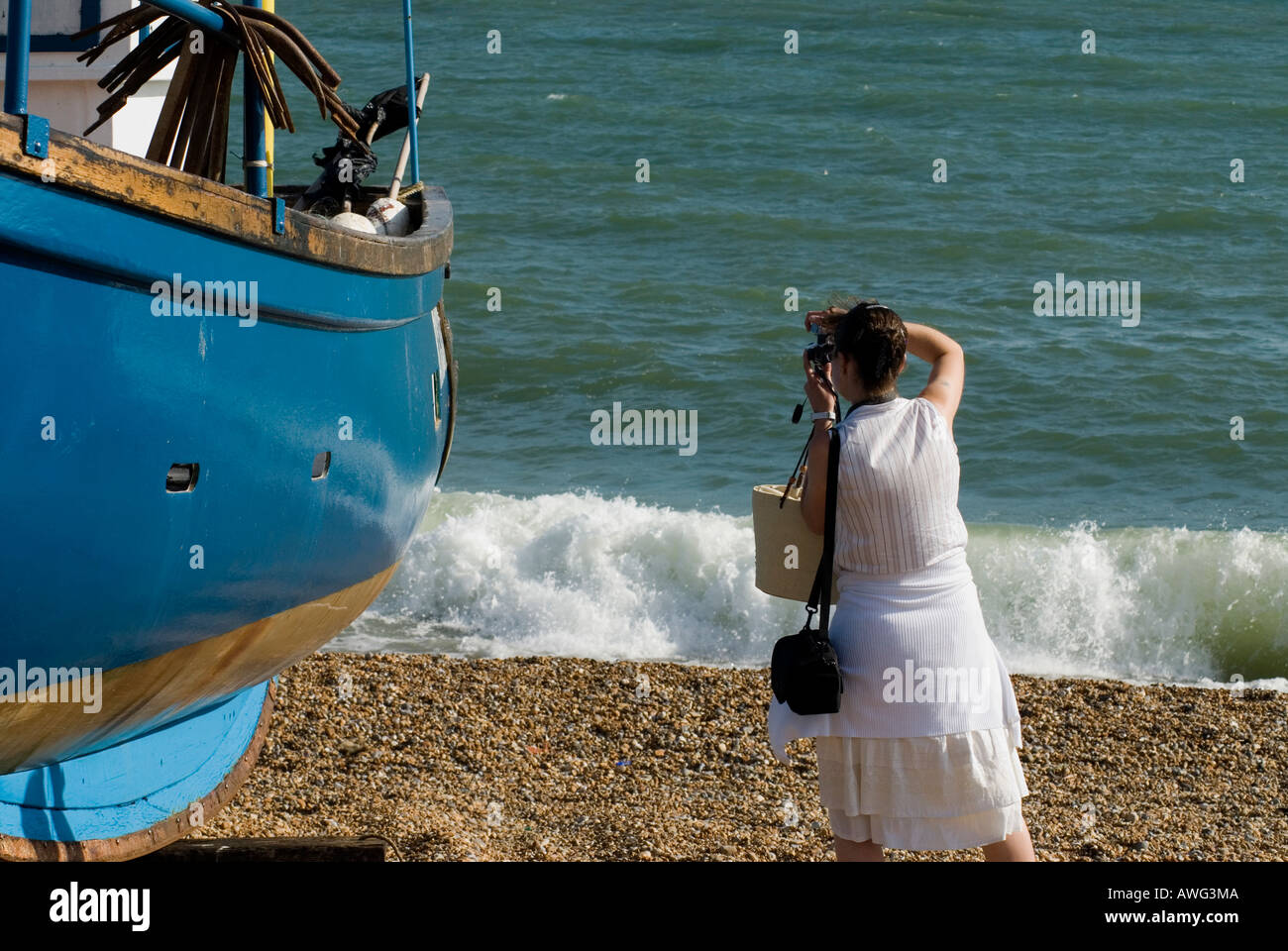 Tourist taking photographs of fishing boat on Rock a Nore Beach the ...