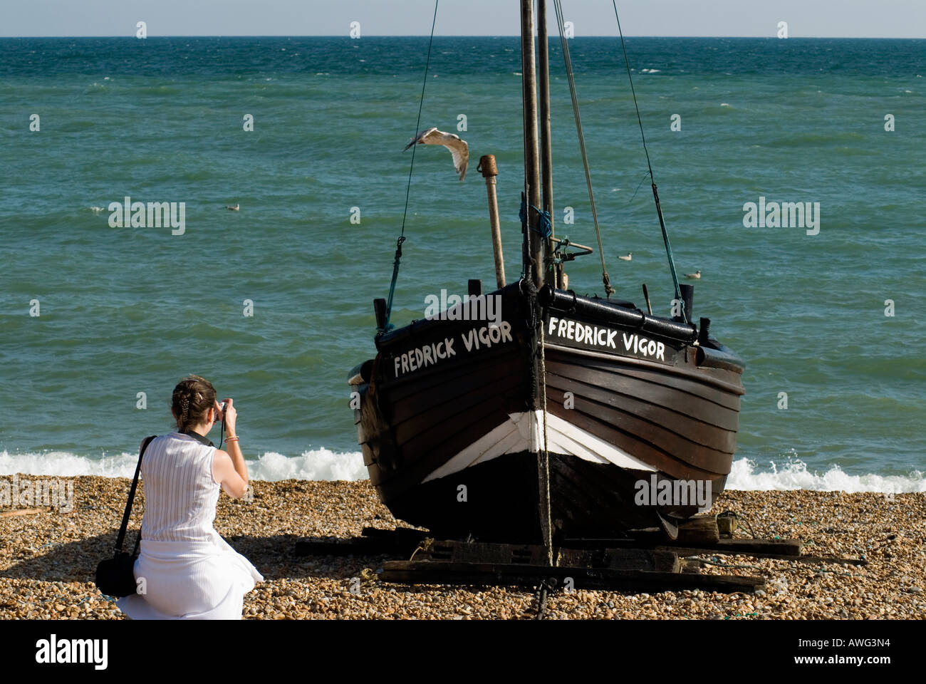 Tourist taking photographs of fishing boat on Rock a Nore Beach the ...