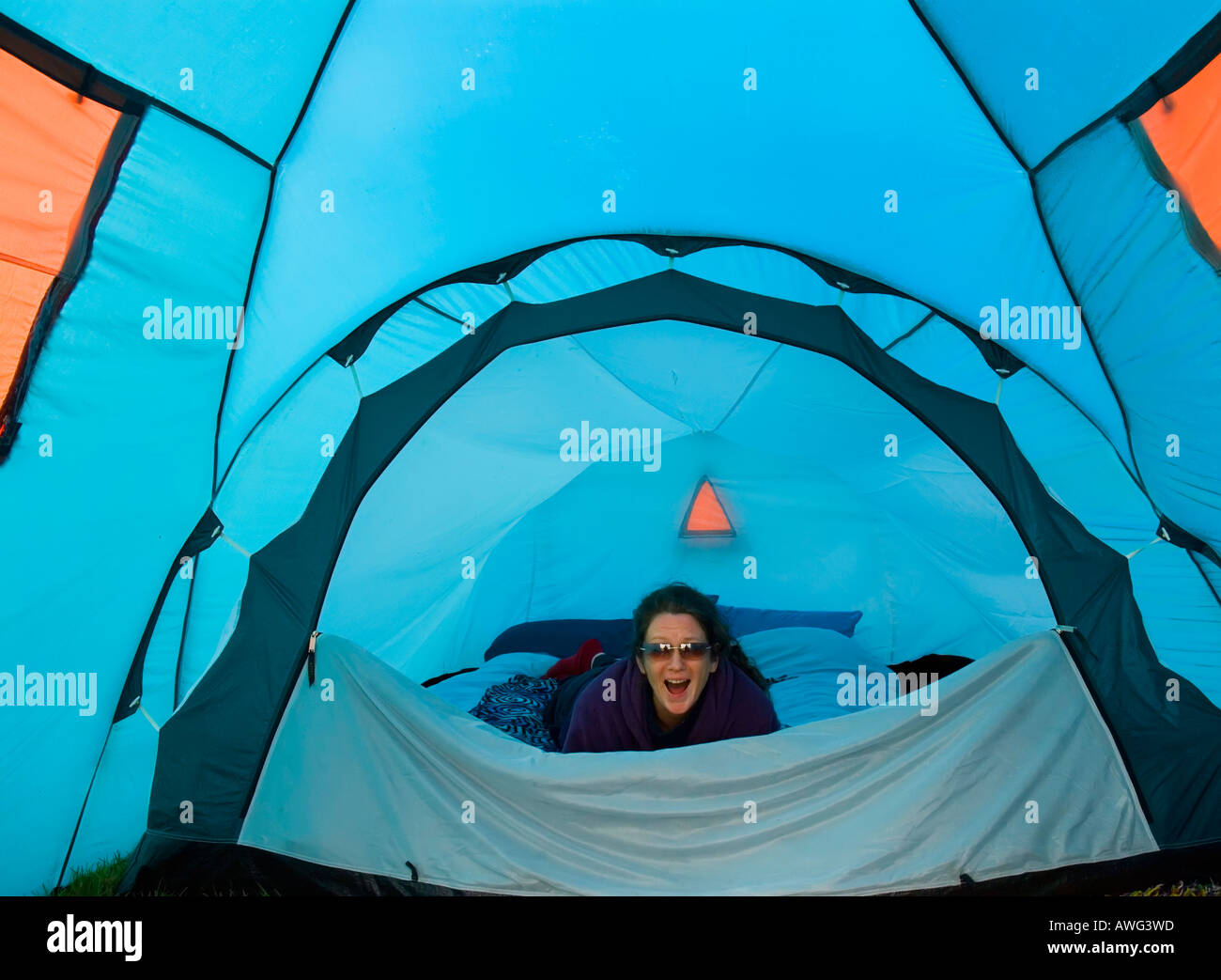 Laughing camper in warm dry tent blue and orange interior Stock Photo ...